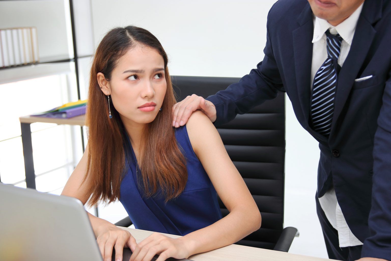 Angry unhappy Asian secretary woman looking hand’s boss touching her ...